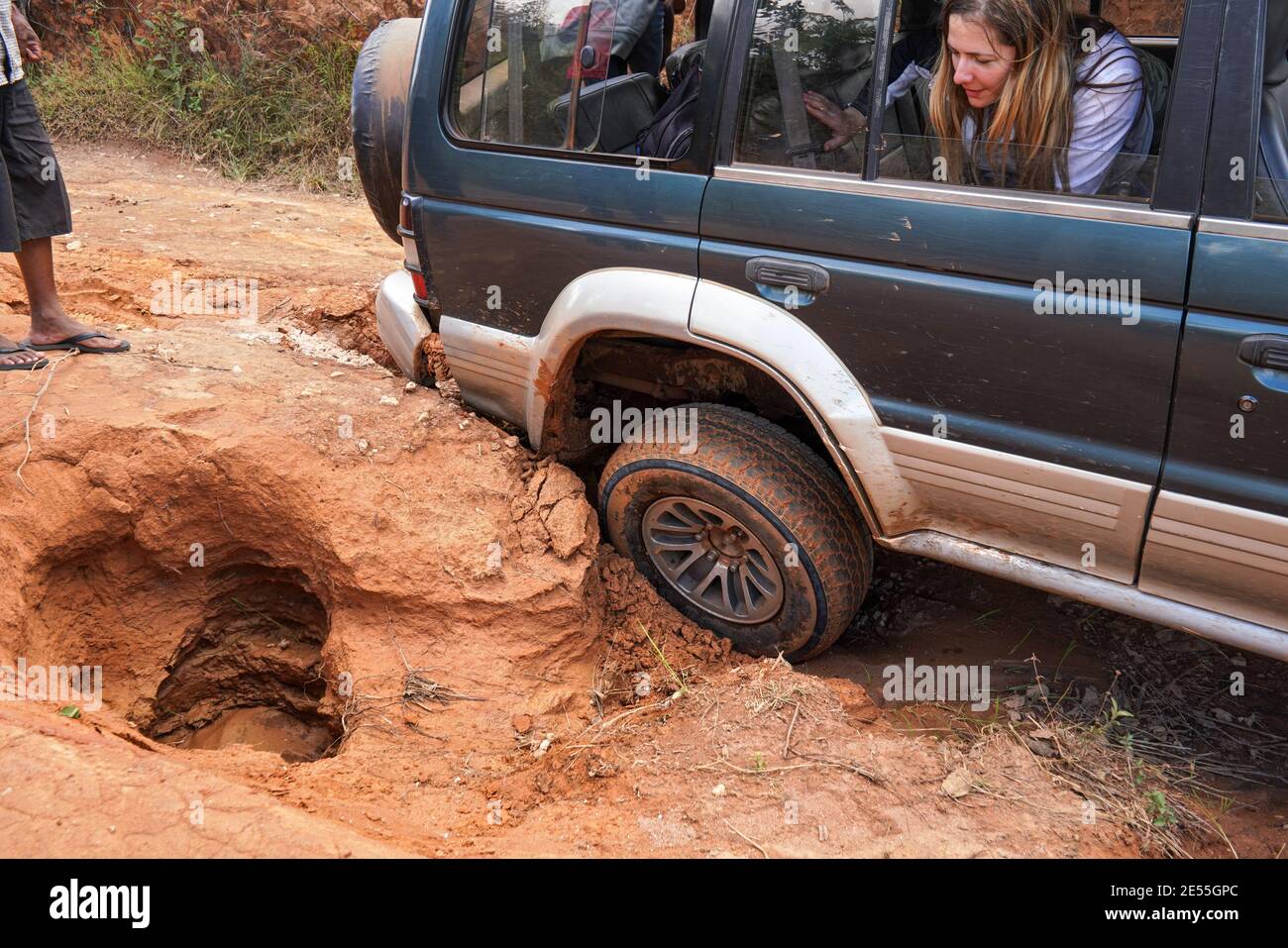 4wd car driving over large holes in dust and mud road - these are in ...