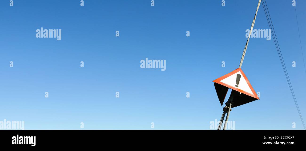 Red triangle with exclamation mark on steel cable of electric pylon ...