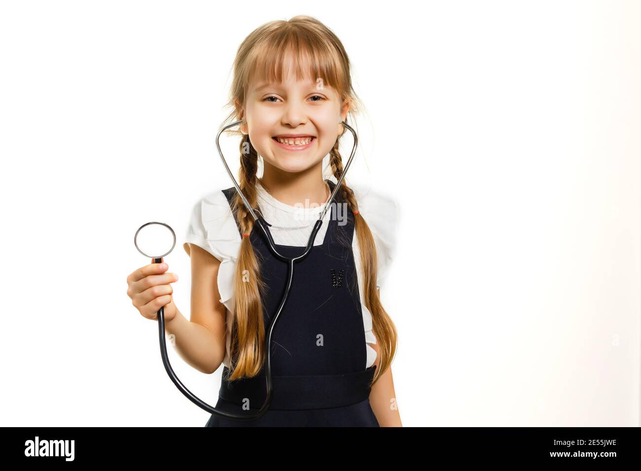 Smiling little girl playing doctor with stethoscope isolated on white ...