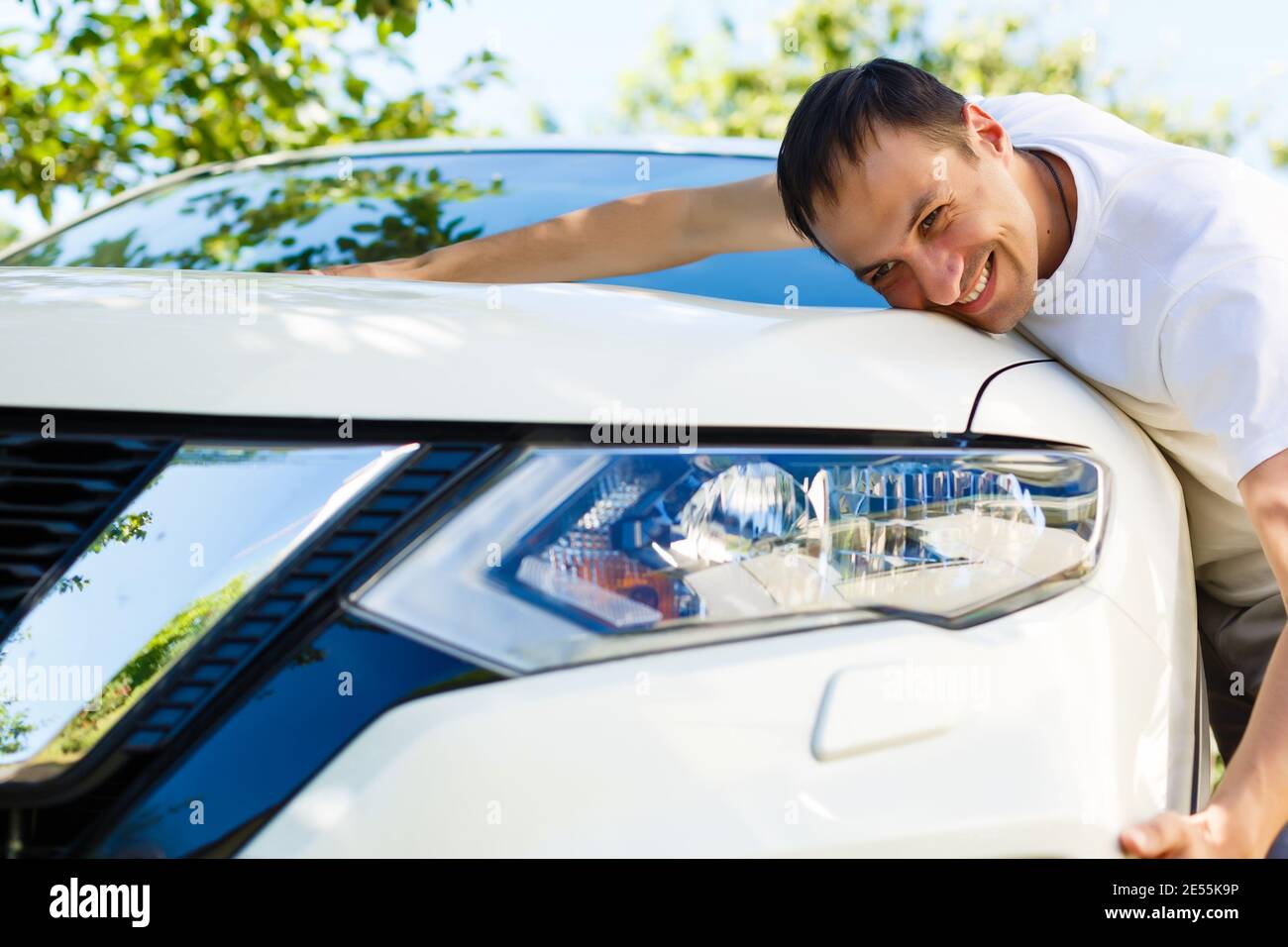 Man hugging on a car in a car dealership Stock Photo - Alamy