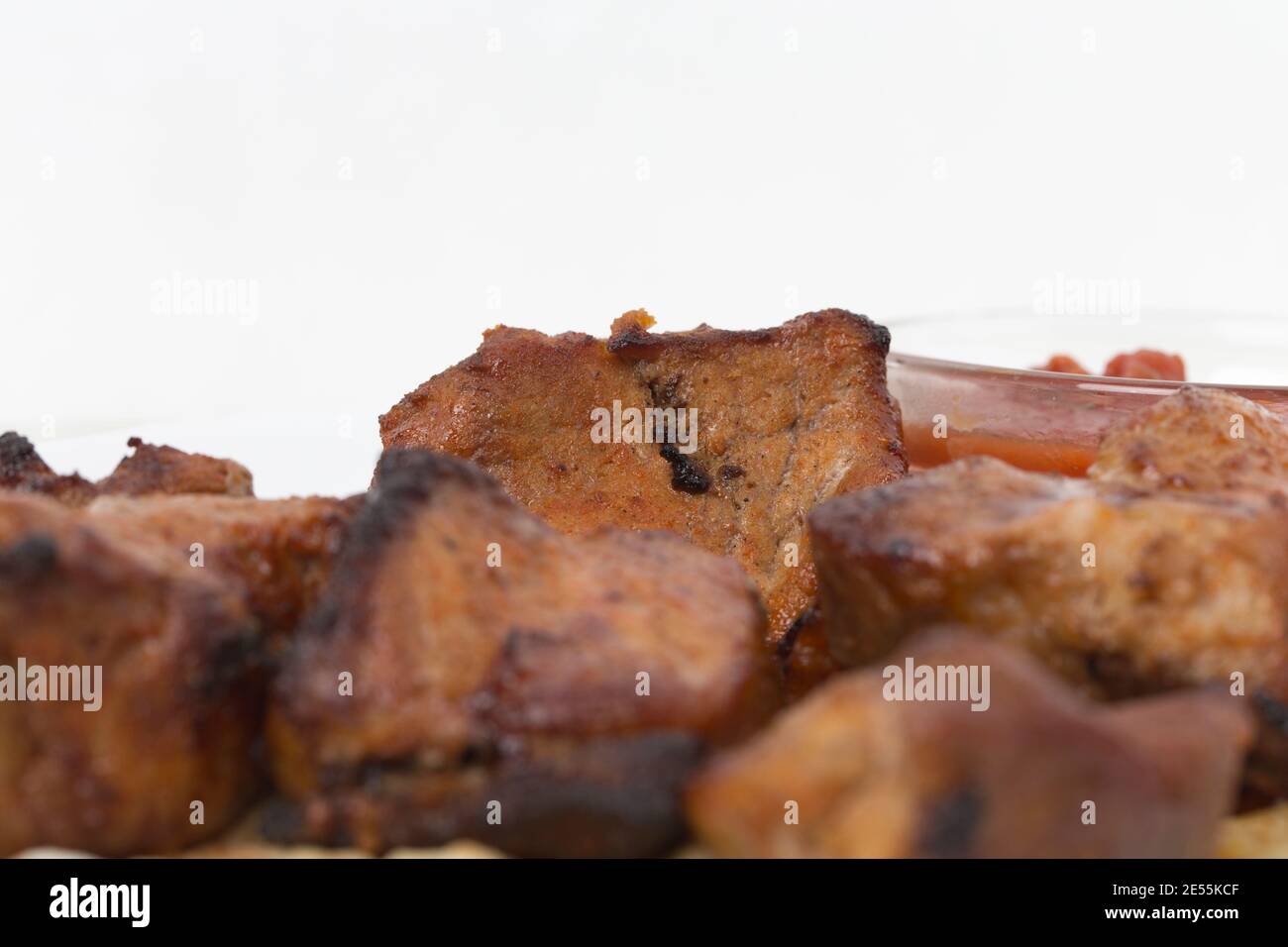 Pieces of fried meat close up on a white background. There is a place ...