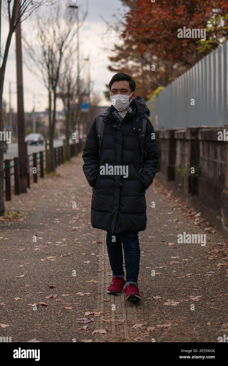 Fukuoka, Japan - January 17 2020: A man wearing jacket and mask with ...