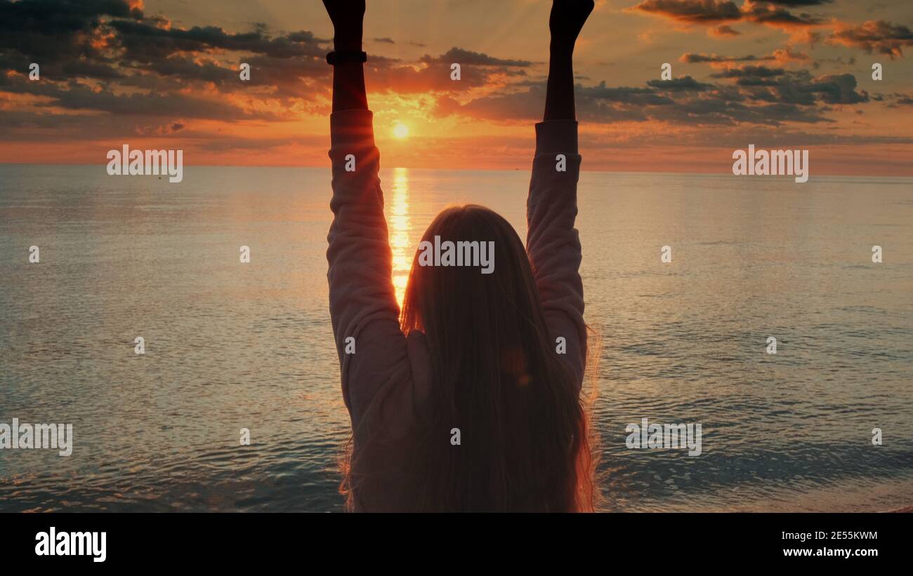 Back woman raising hands hi-res stock photography and images - Alamy