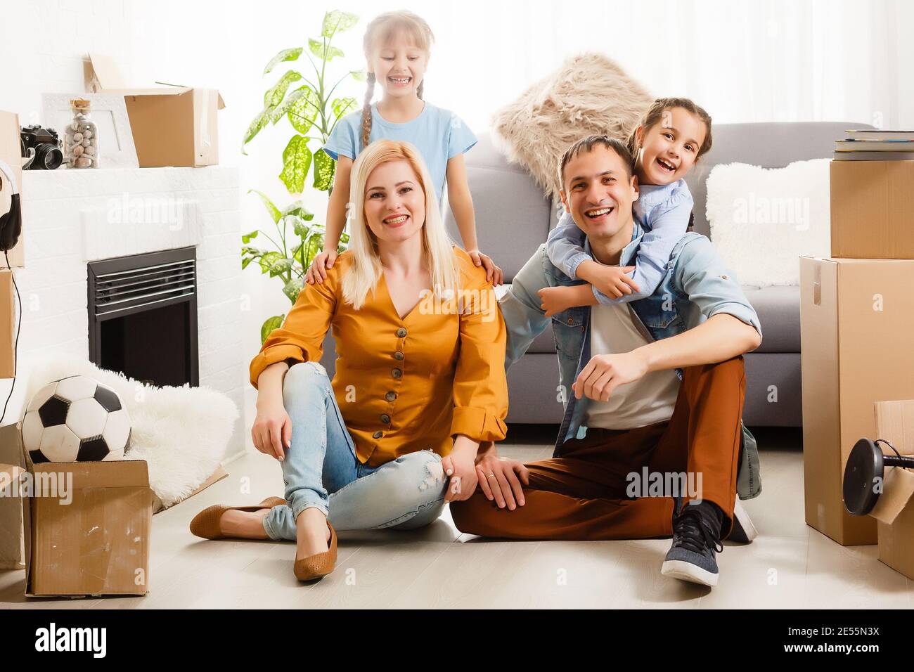 Happy family moving home with boxes around Stock Photo - Alamy
