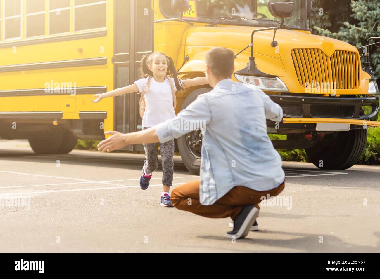Father meeting little daughter coming out of school bus Stock Photo - Alamy