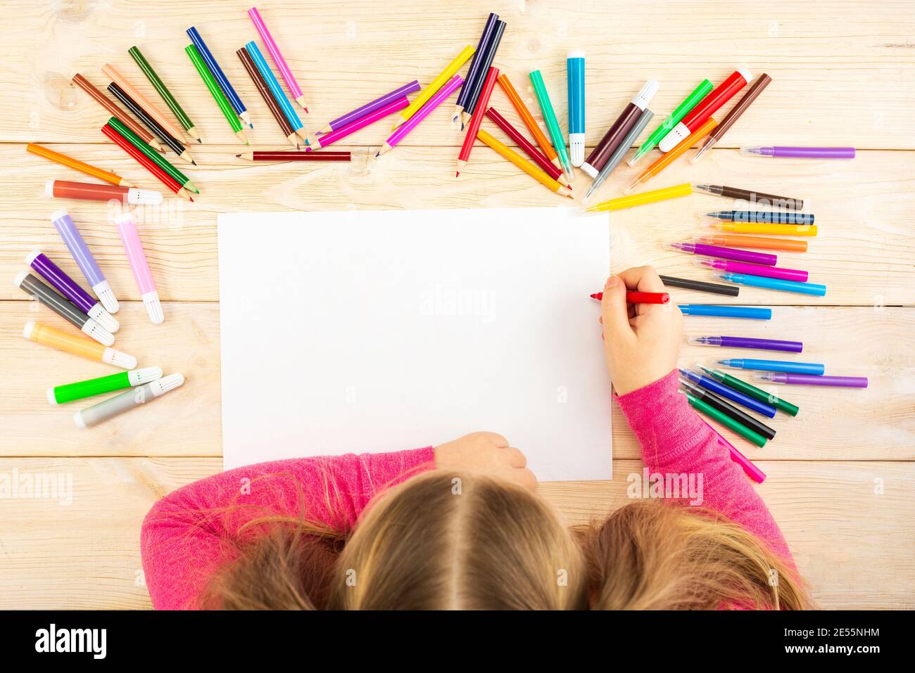Little girl prepares to paint on a blank sheet of paper. Drawing is ...