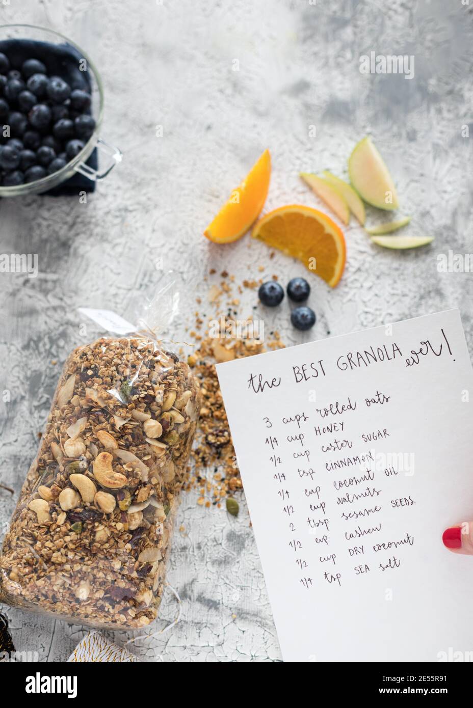 Granola recipe held by a woman hand written with lettering over some ...