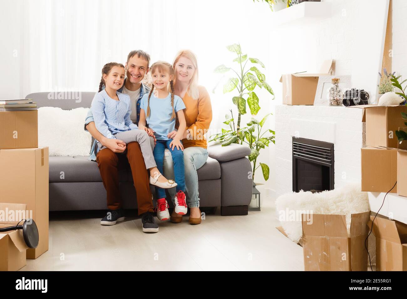 Happy family with cardboard boxes in new house at moving day Stock ...