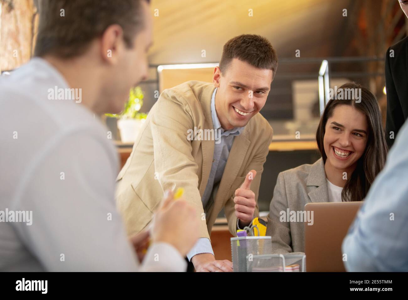 Deciding. Front view colleagues working together in a office using ...