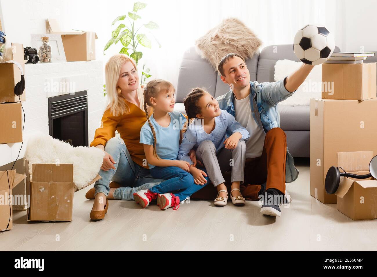 Happy family moving home with boxes around Stock Photo - Alamy