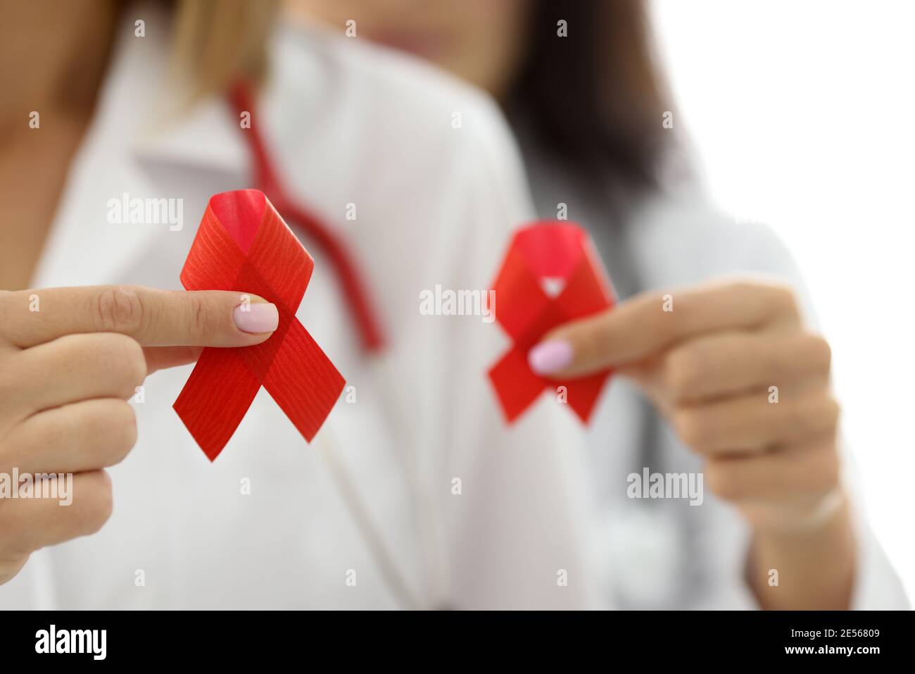 Two doctors are holding red ribbon in their hands Stock Photo - Alamy