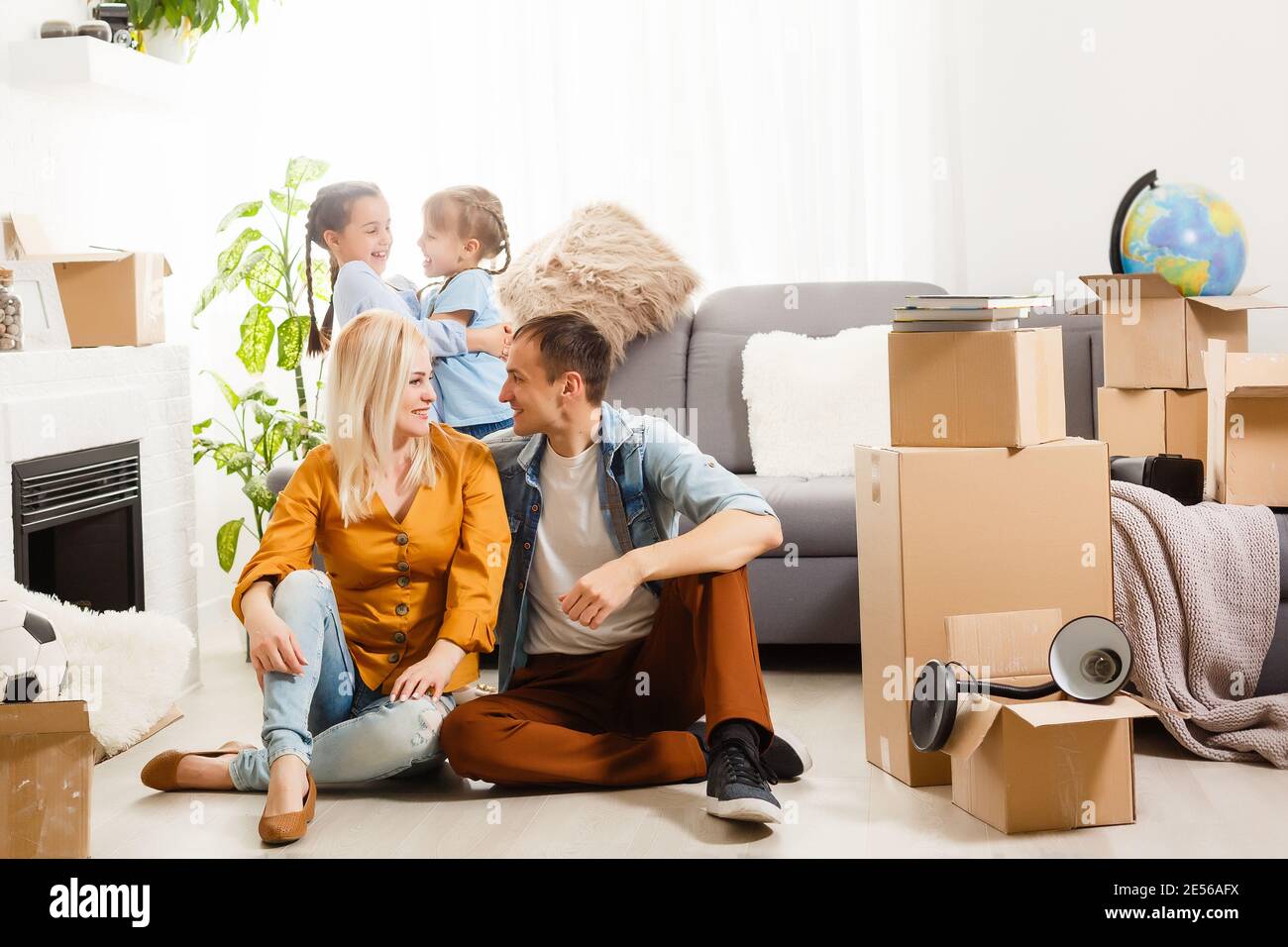 Happy family with cardboard boxes in new house at moving day Stock ...
