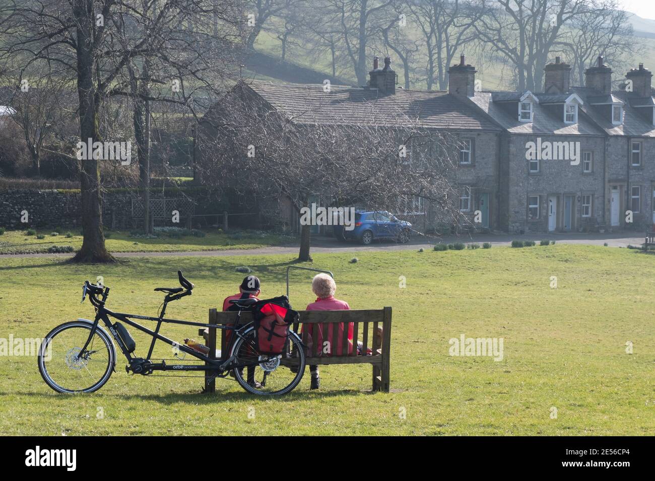 A couple take a rest from their tandem bike on a bench in Langcliffe in ...