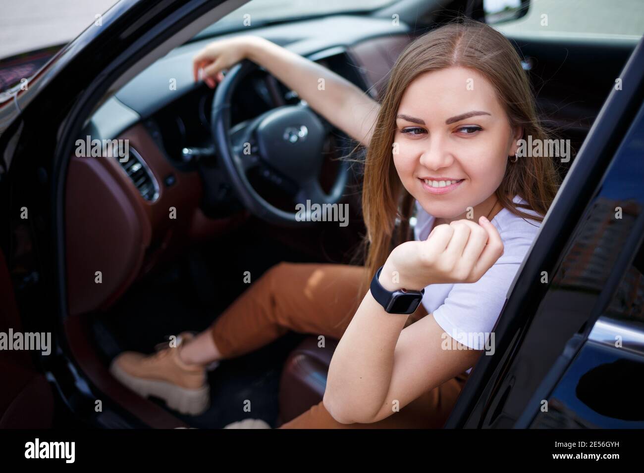 Beautiful blonde woman driver driving a black car. Concept of rich ...