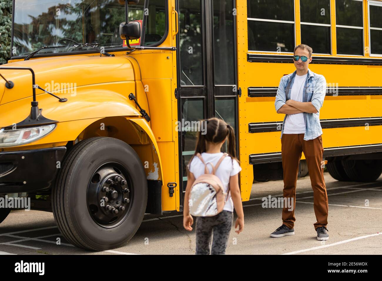 Smiling bus driver looking at camera outside the elementary school ...