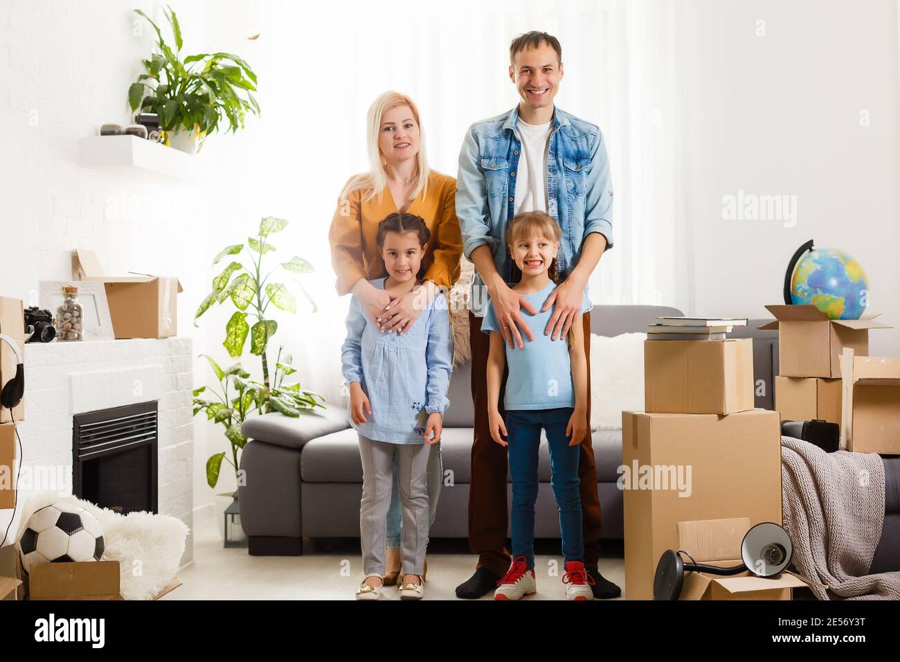 Happy family moving home with boxes around Stock Photo - Alamy