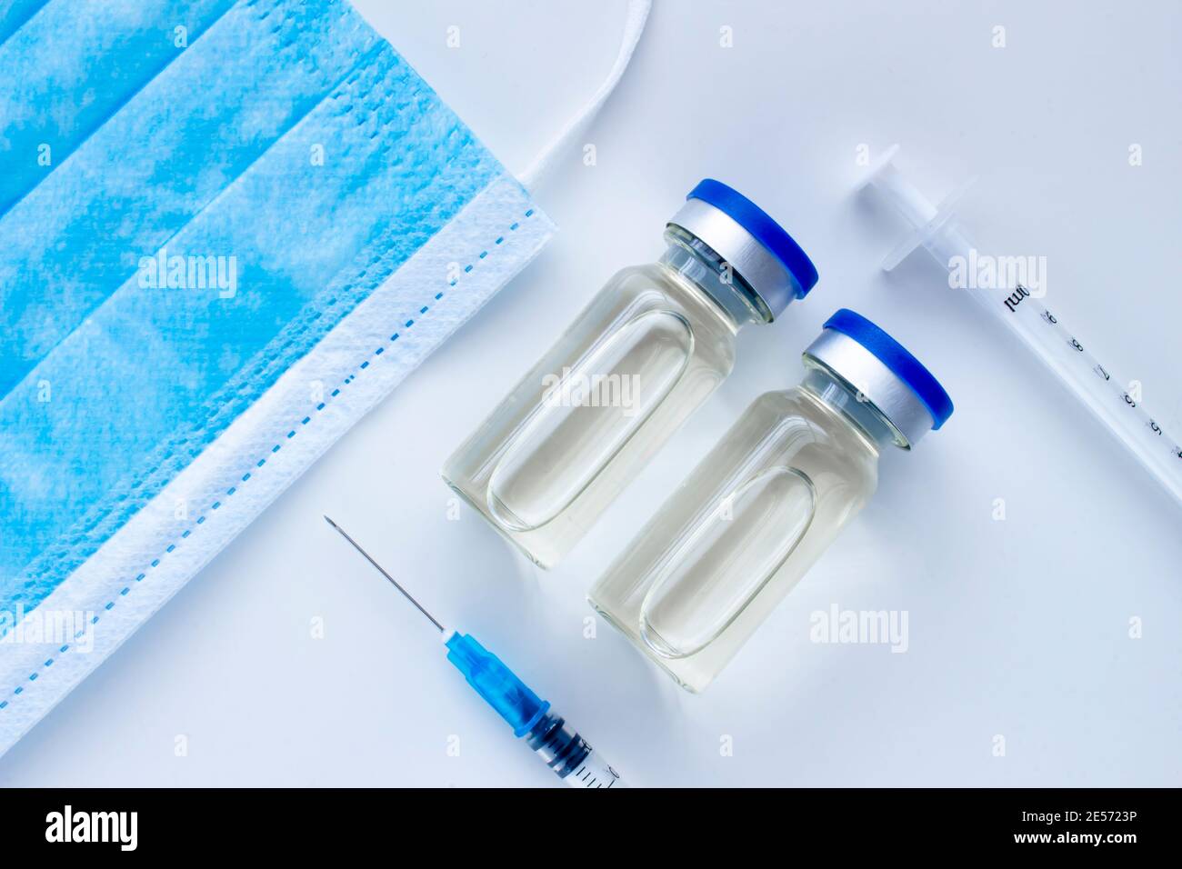 A couple of vaccine vial bottles with Sterile Syringes and a face mask ...