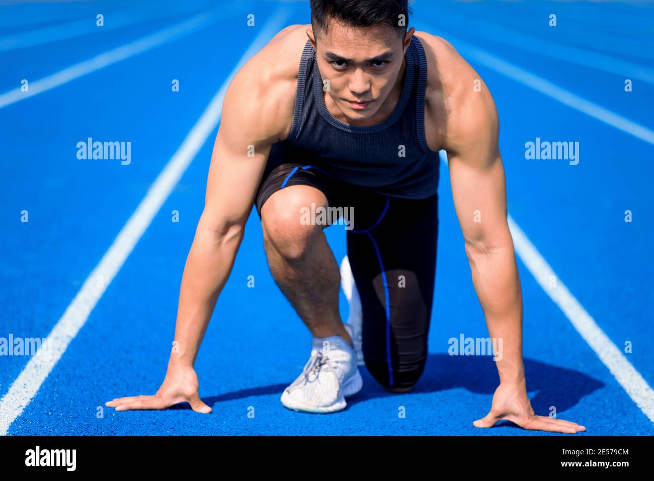 Male athlete on race track is ready to run Stock Photo - Alamy
