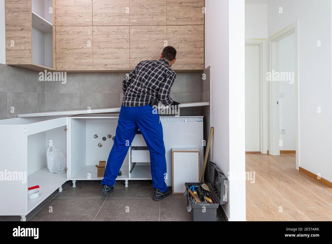 The carpenter puts the kitchen working surface in place, in the almost ...