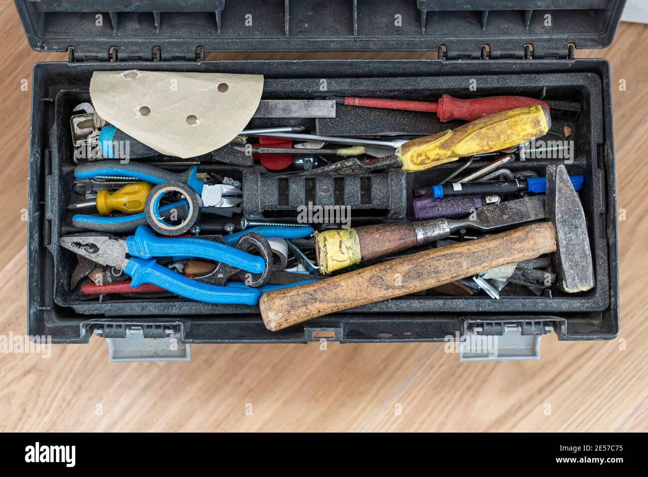 An open tool box photographed from above with many different tools in ...