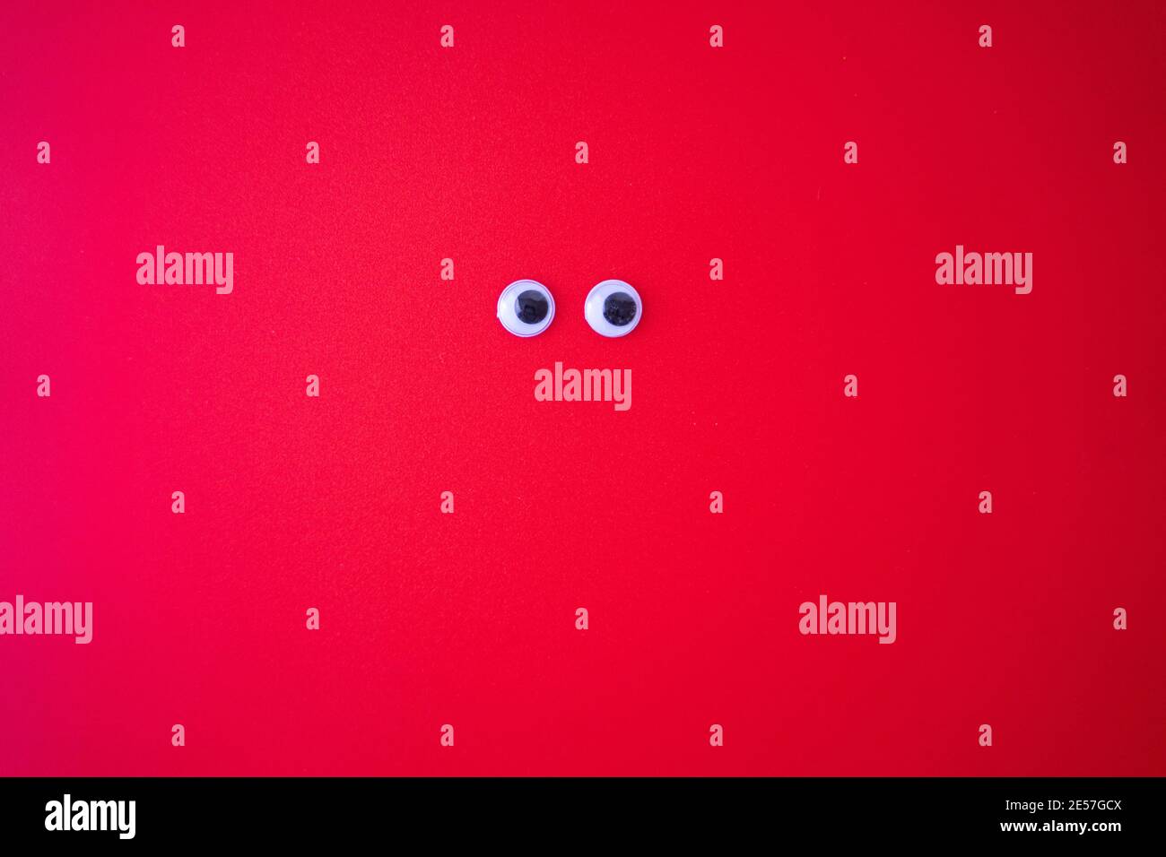 red background with toy's eyes Stock Photo - Alamy