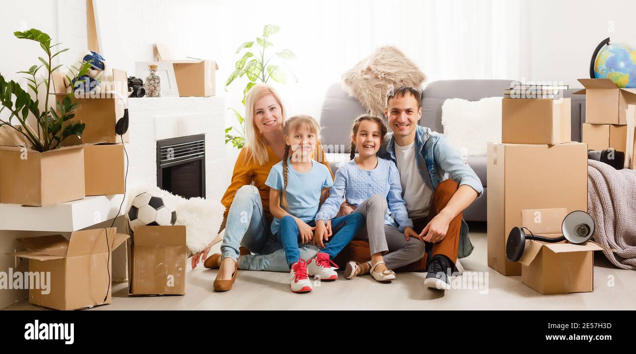 Happy family moving home with boxes around Stock Photo - Alamy