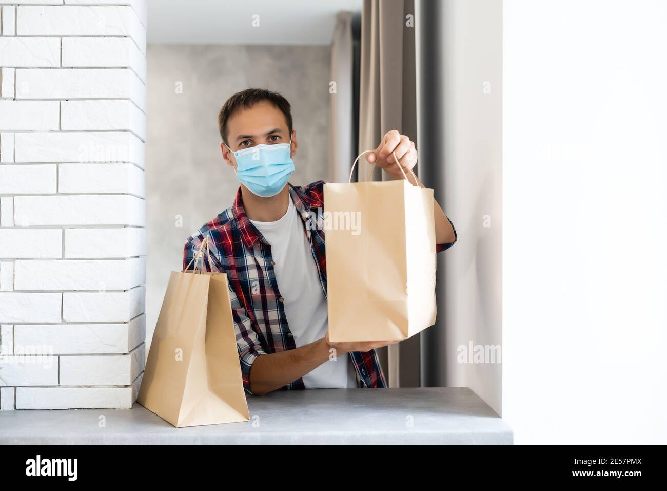 Delivery man holding paper bag with food, food delivery man in ...