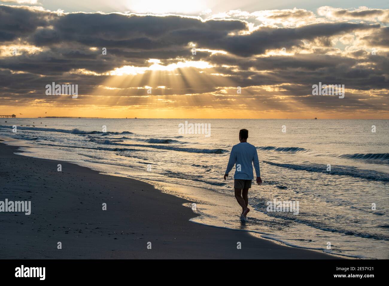 One person walk along the shoreline at dawn at Atlantic Beach, North ...
