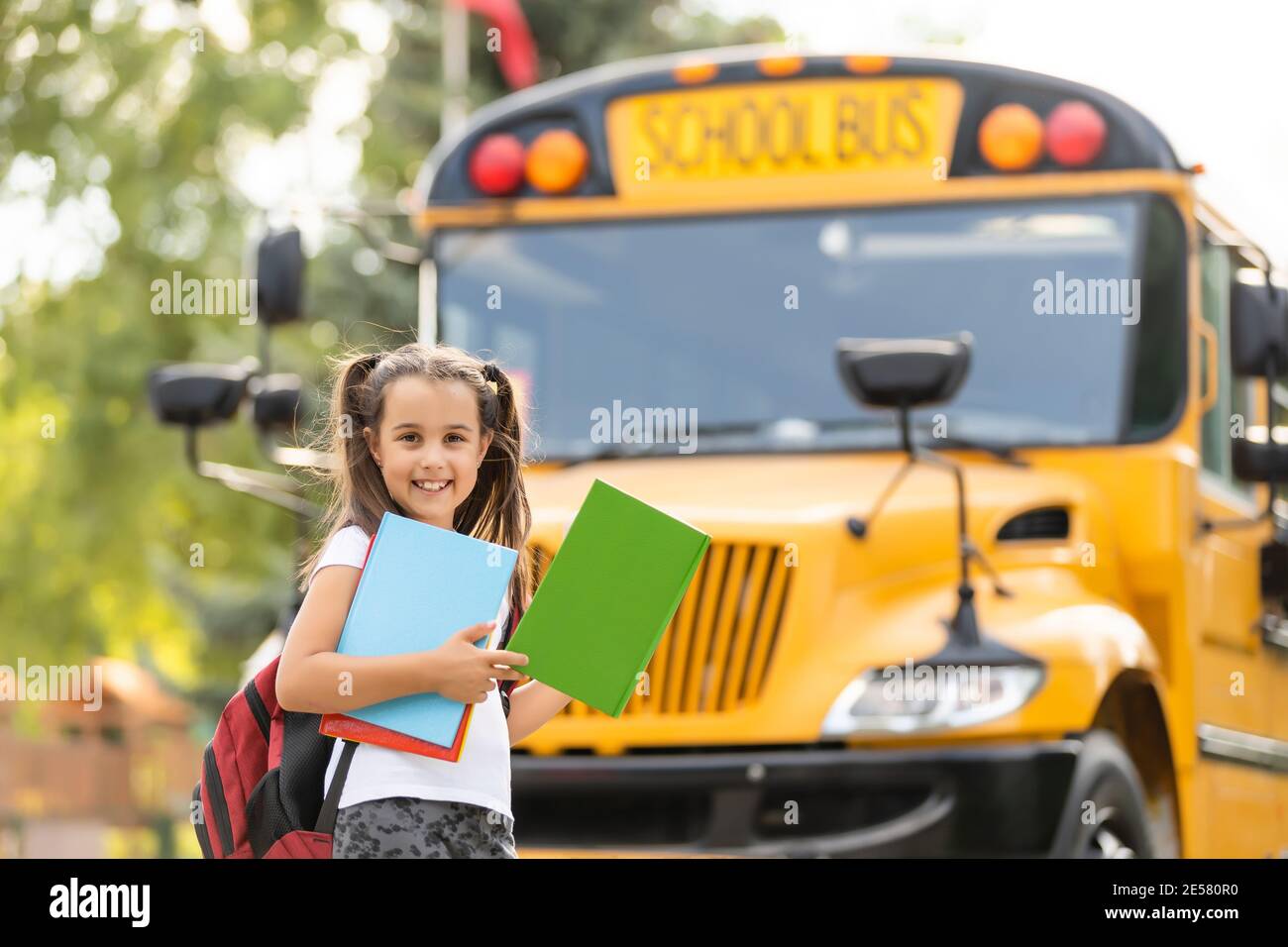 Girl with backpack near yellow school bus. Transport for students Stock ...