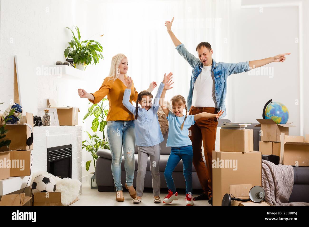 Happy family moving home with boxes around Stock Photo - Alamy