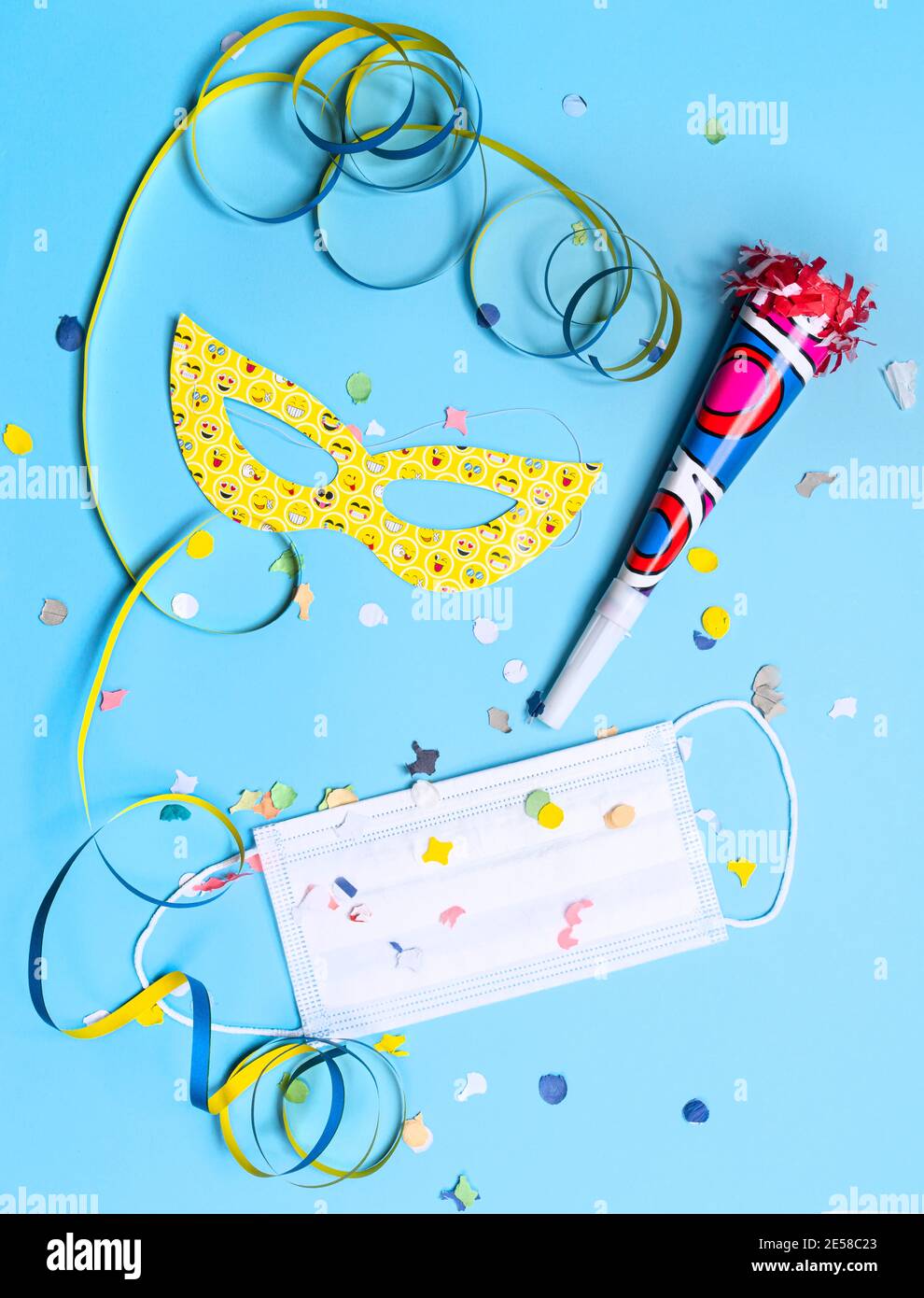 masks, confetti, treamers and mask on a colorful carnival table during ...