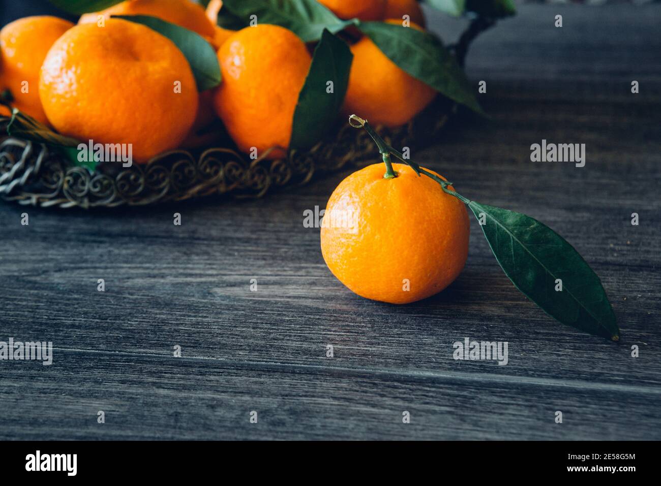 Ripe Mandarin fruit peeled open and place on old rustic look timber ...