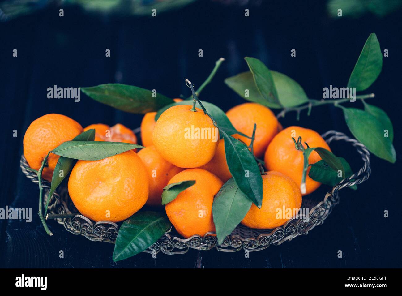 Ripe Mandarin fruit peeled open and place on old rustic look timber ...