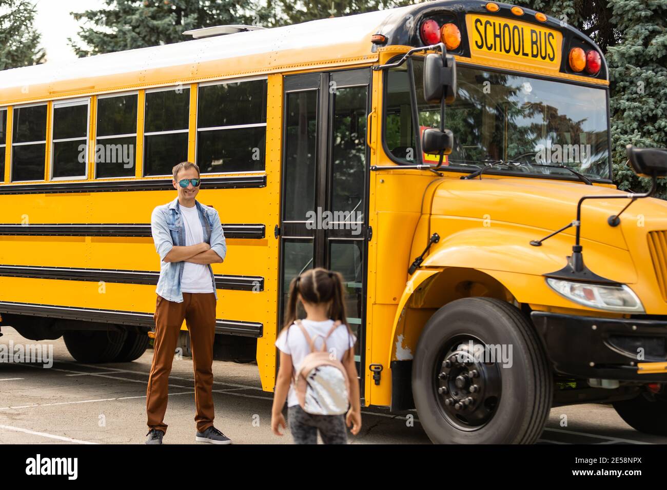 school bus driver is standing in front of his bus Stock Photo - Alamy