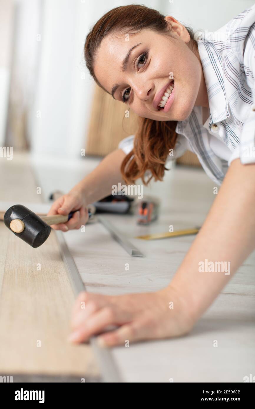 happy young woman installing laminate floor tile Stock Photo - Alamy
