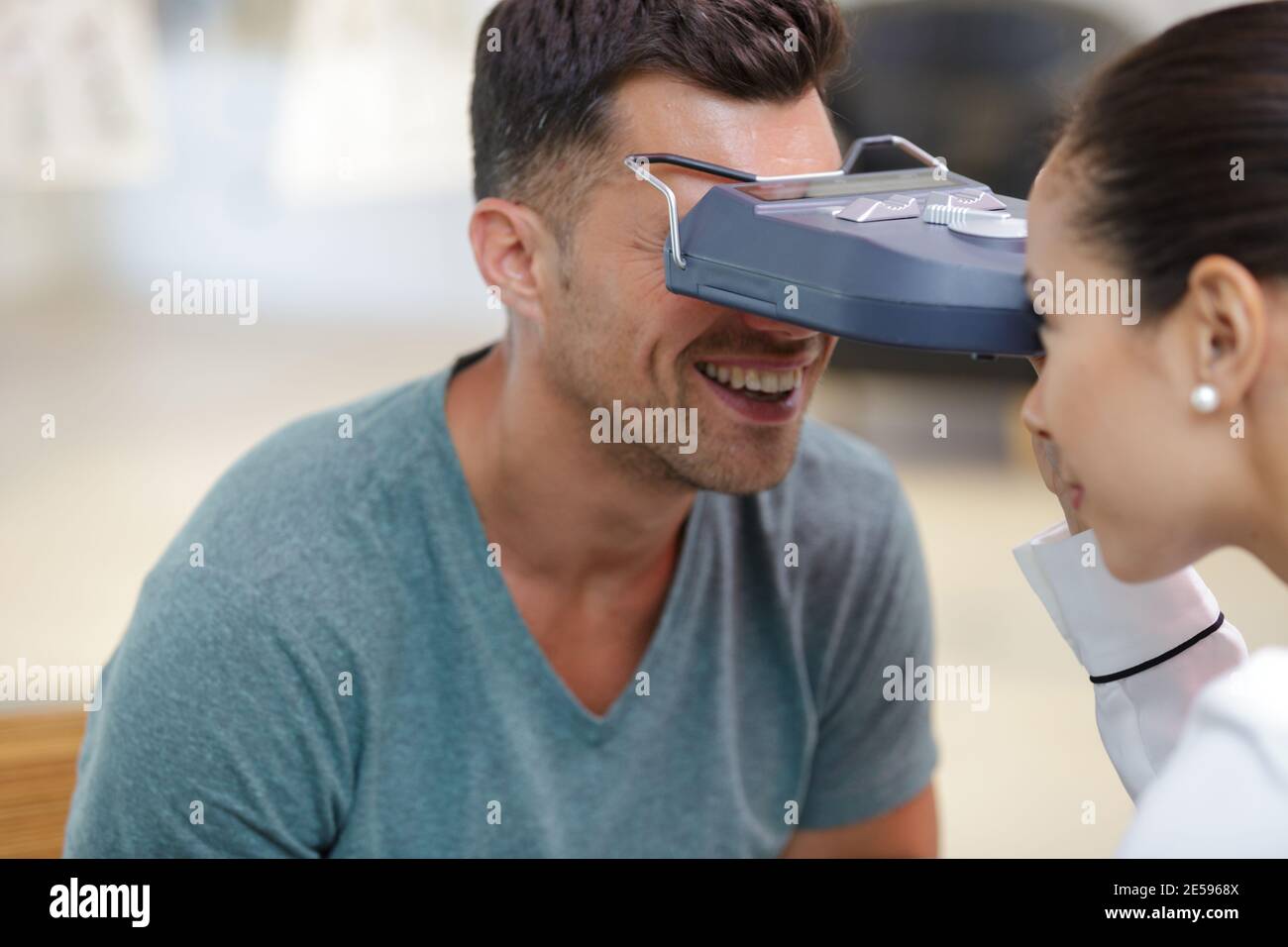 ophthalmologist using handheld device to inspect patients eyes Stock ...