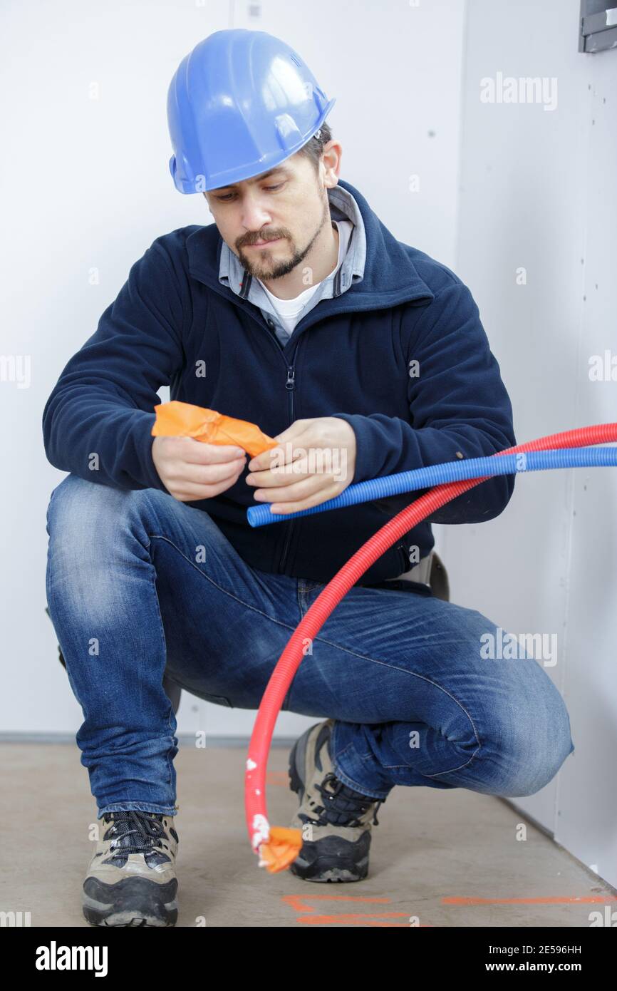builder holding cables taped together Stock Photo - Alamy