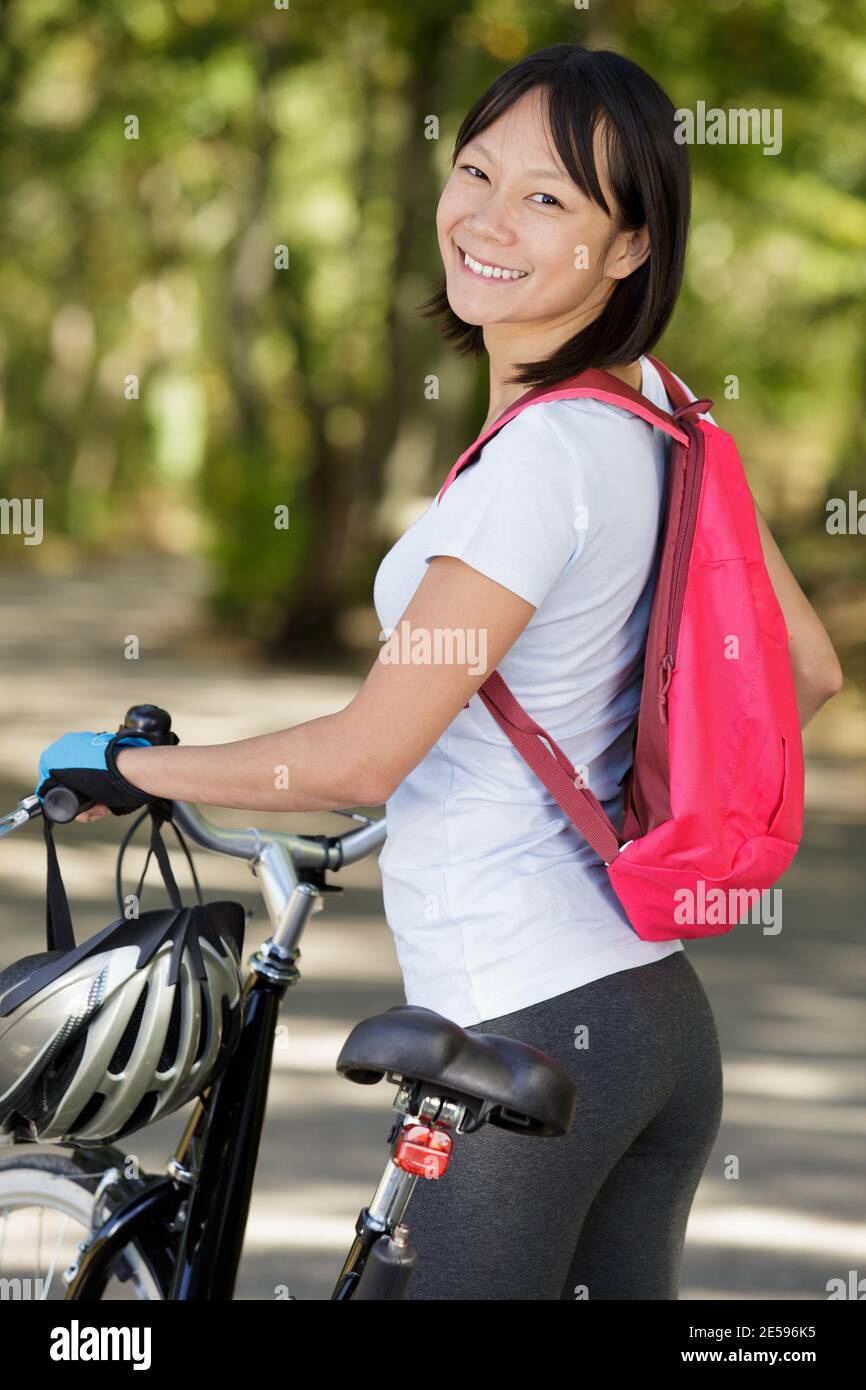 woman next to a bike looking back at camera Stock Photo - Alamy