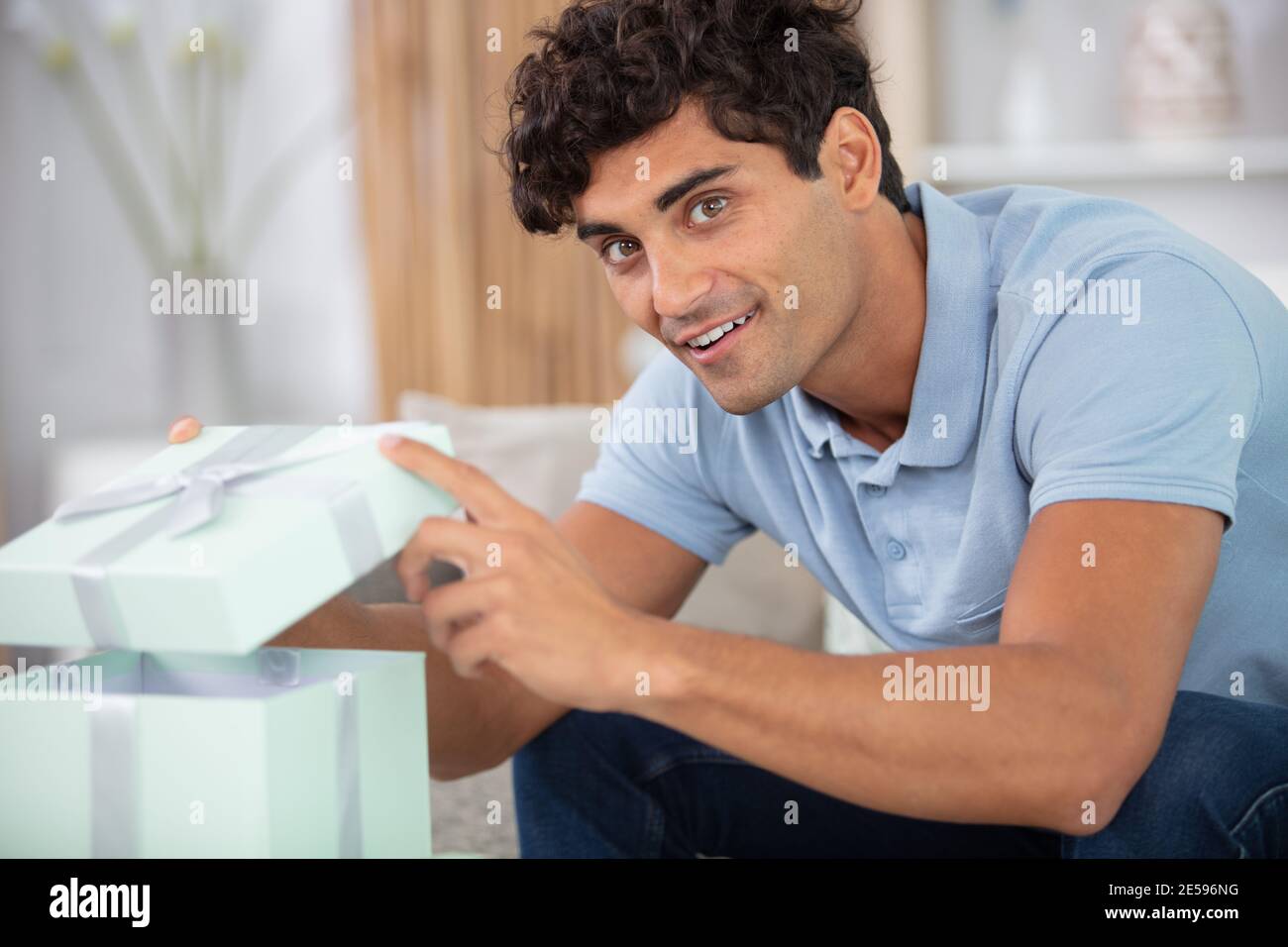 surprised man opening big gift box Stock Photo - Alamy