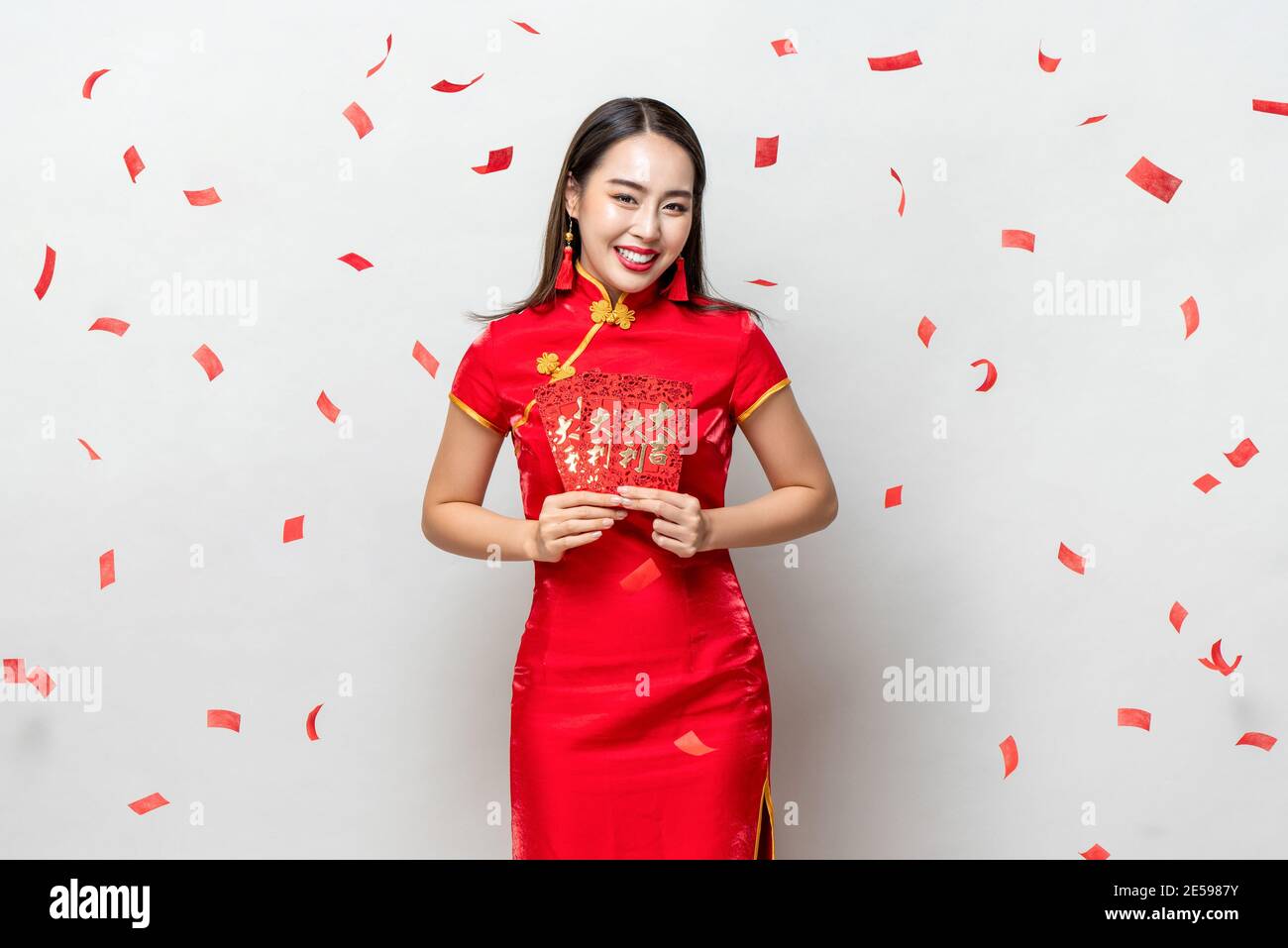 Smiling happy Asian woman in traditional oriental costume holding red ...