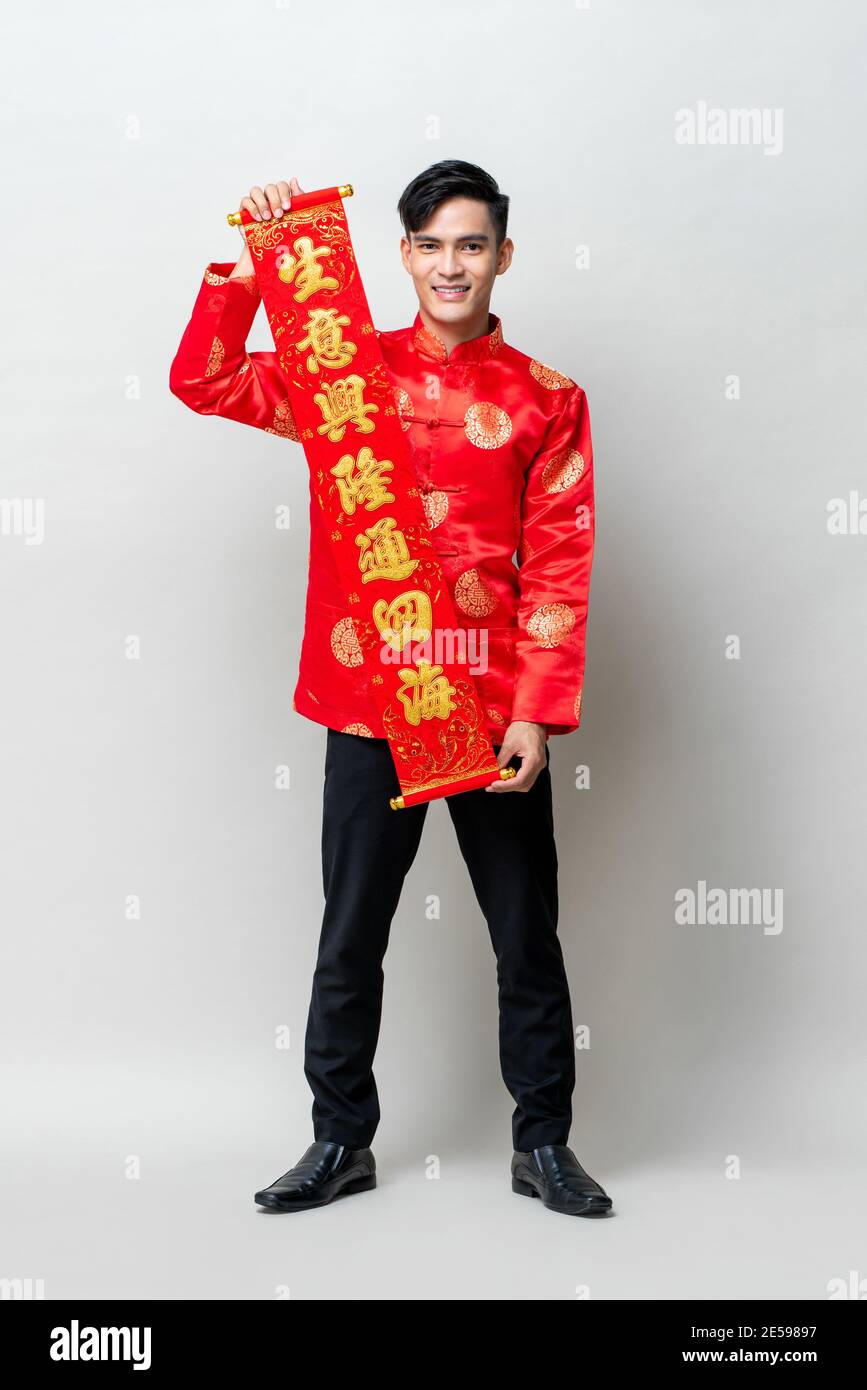 Handsome smiling Asian man showing red label in isolated studio light ...