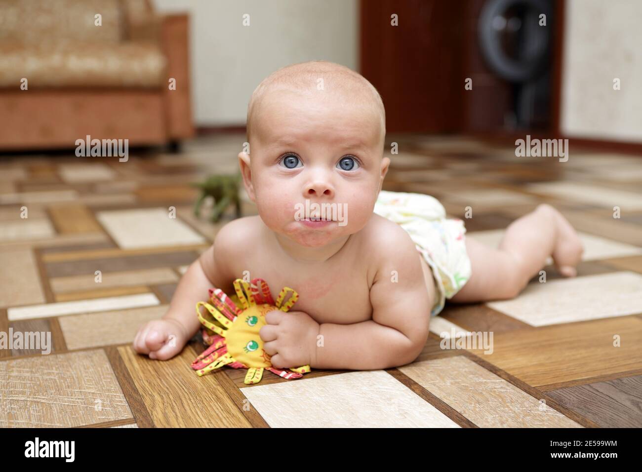 Surprised baby playing on the floor at home Stock Photo - Alamy