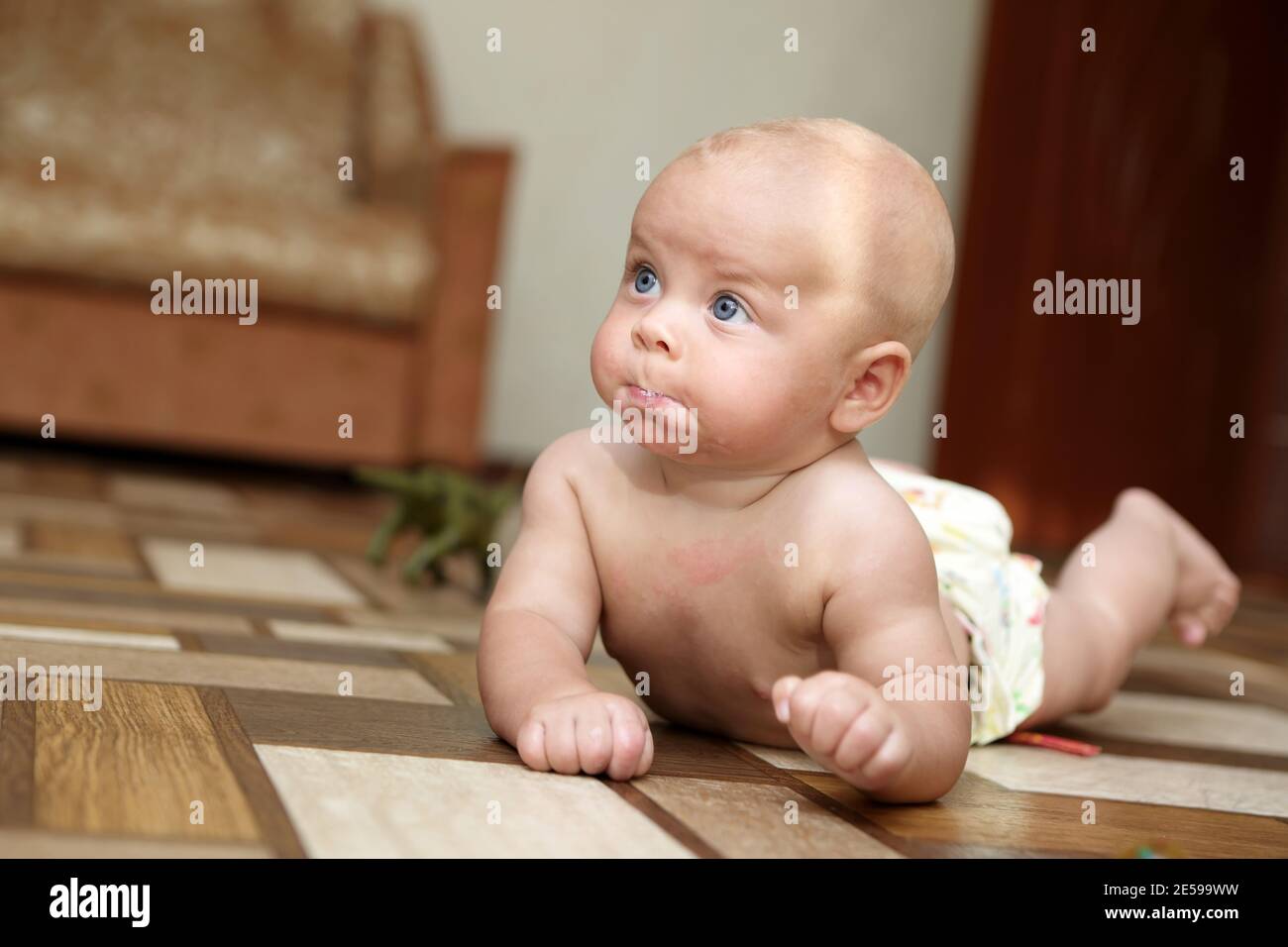 Surprised baby crawling on the floor at home Stock Photo - Alamy