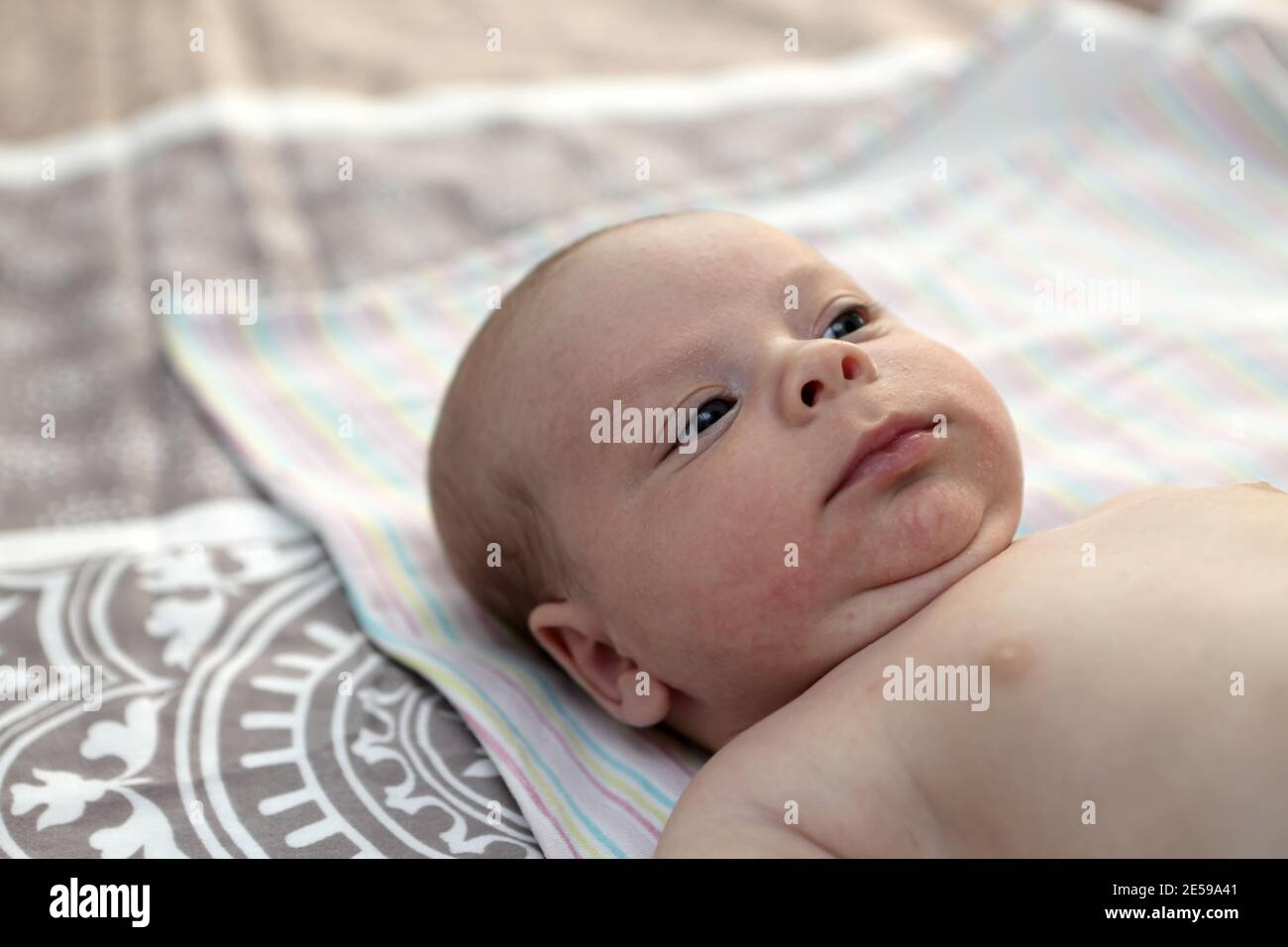 Portrait of a thinking baby on a bed Stock Photo - Alamy