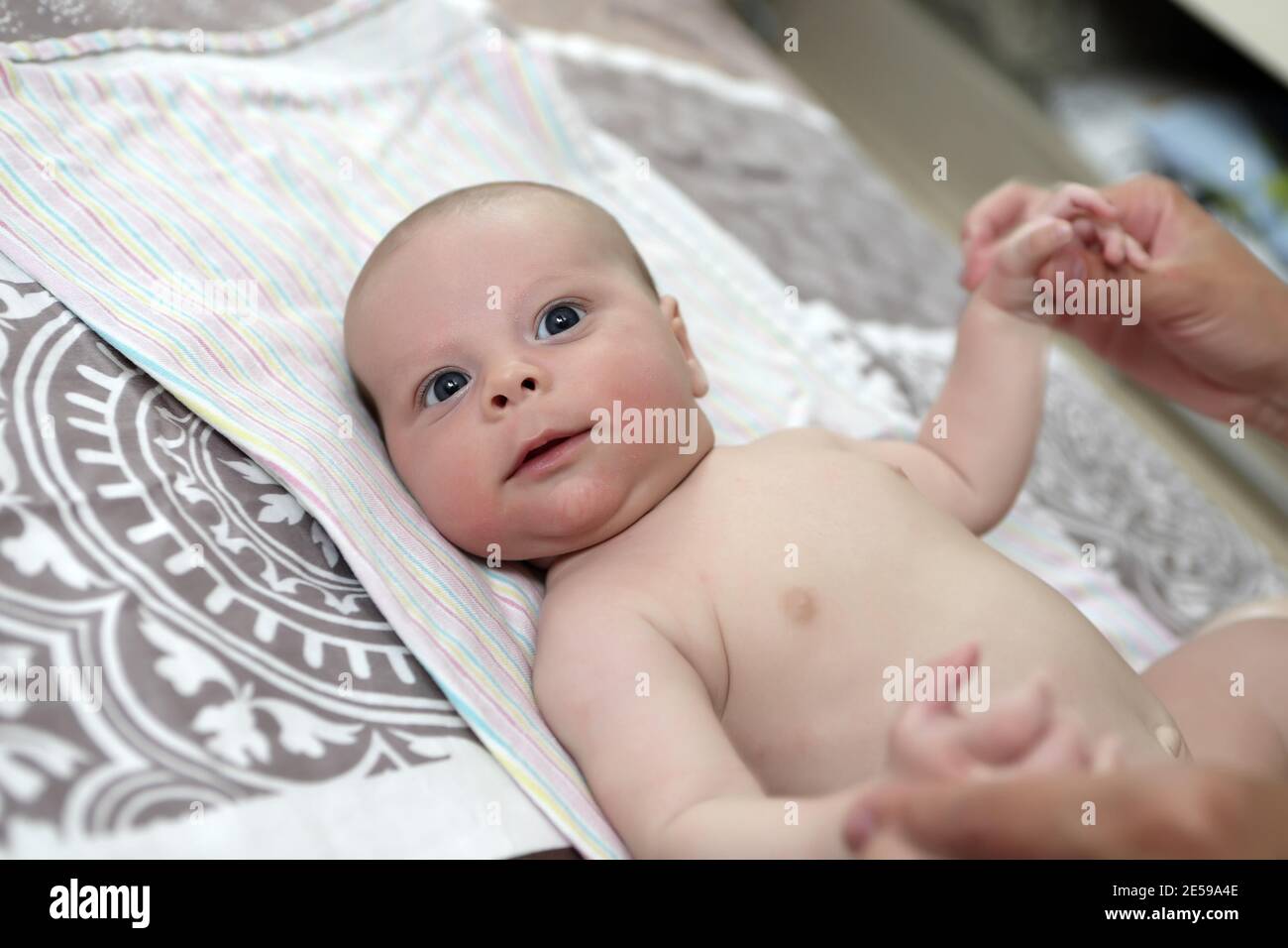 Newborn baby boy doing exercise on the bed at home Stock Photo - Alamy