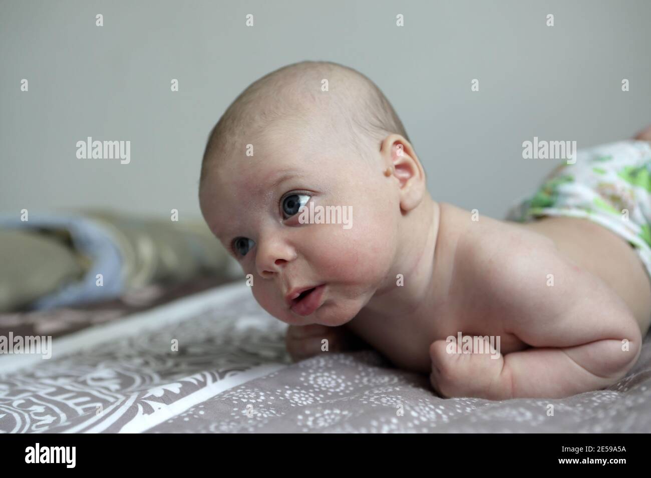 Portrait of a serious baby on a bed Stock Photo - Alamy