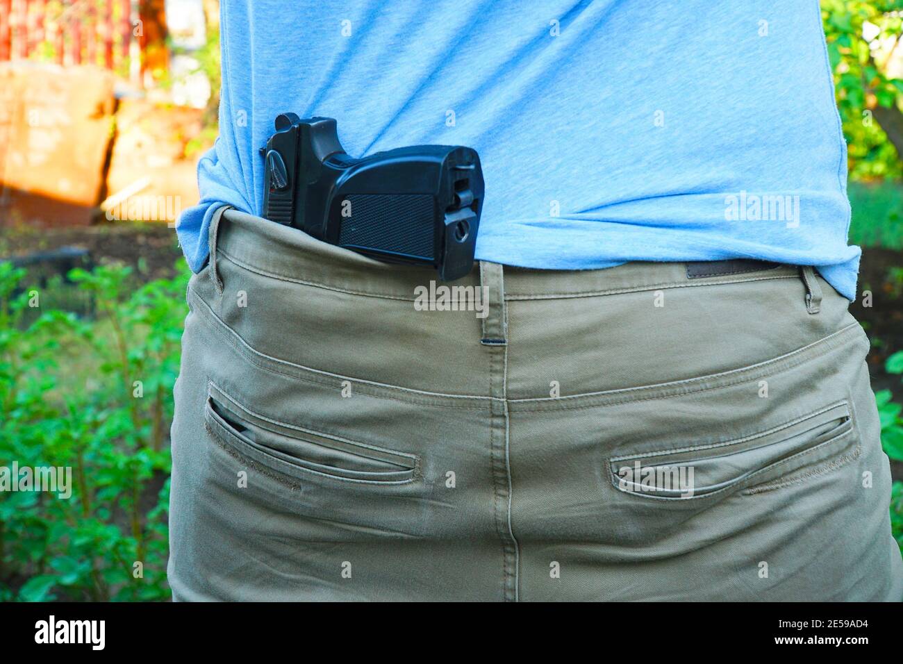 The gun is hidden behind the man's back Stock Photo - Alamy