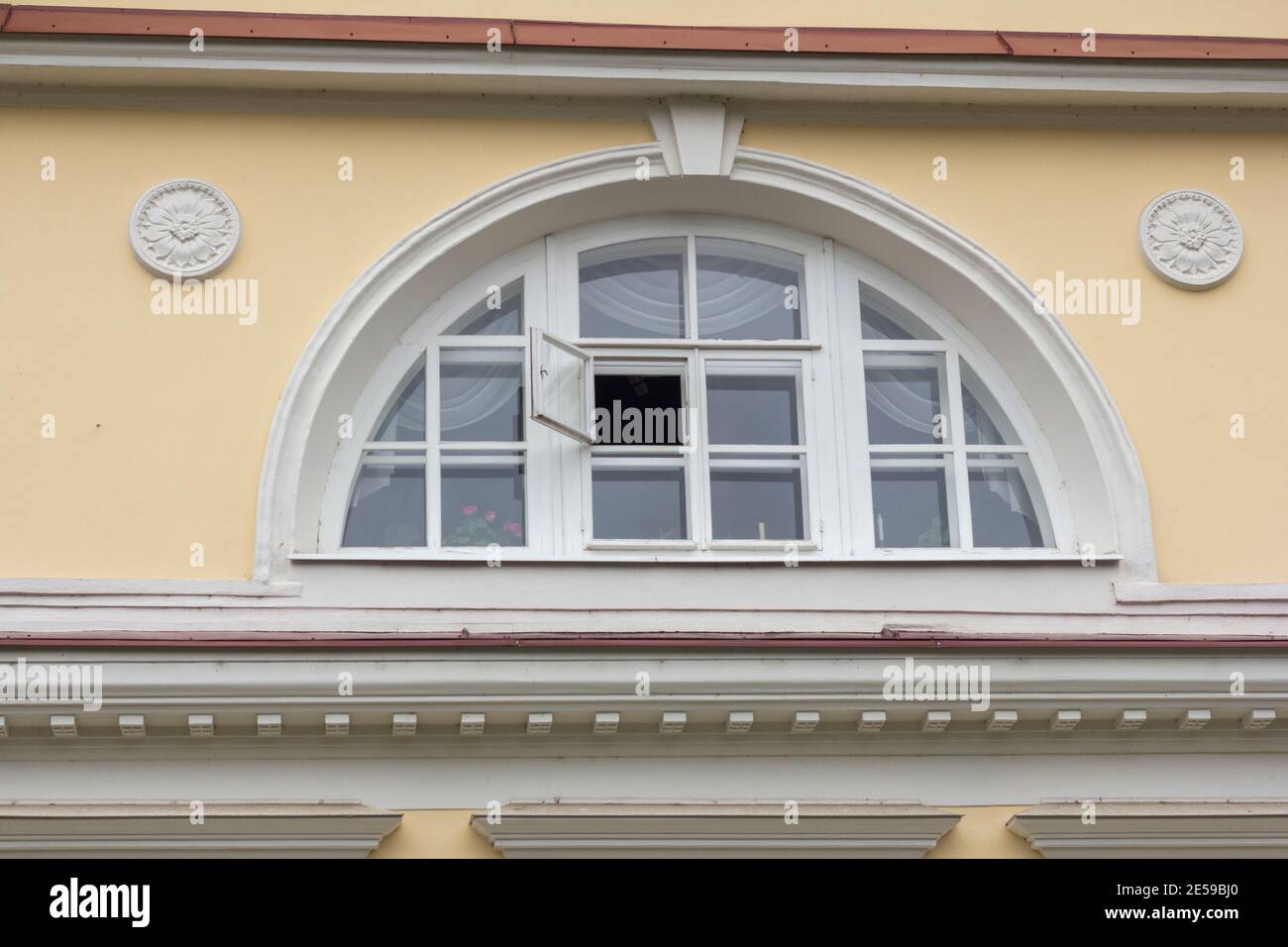 A semicircular window with an open window pane in the old manor museum ...