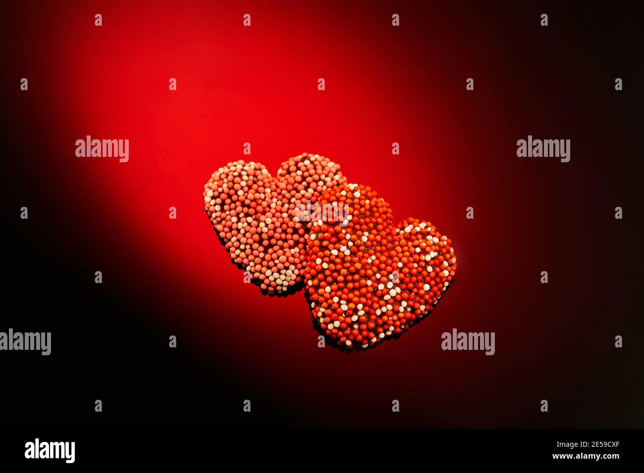 Valentine's Day candies on red black background. Red candy hearts with ...