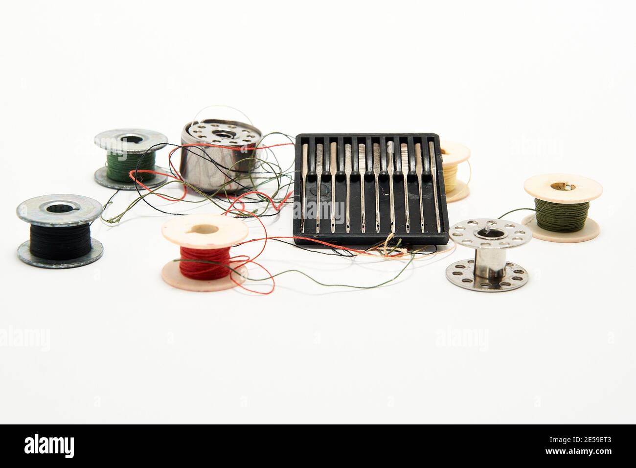 Set of needles and threads for a sewing machine on a white background ...